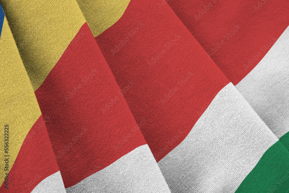 Seychelles flag with big folds waving close up under the studio light ...