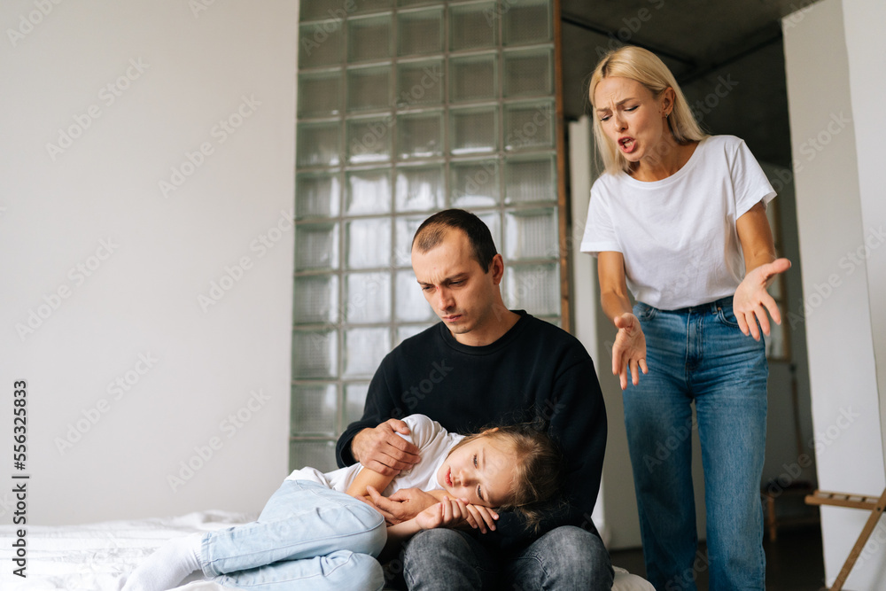Depressed caring young father embracing loving little daughter sitting ...