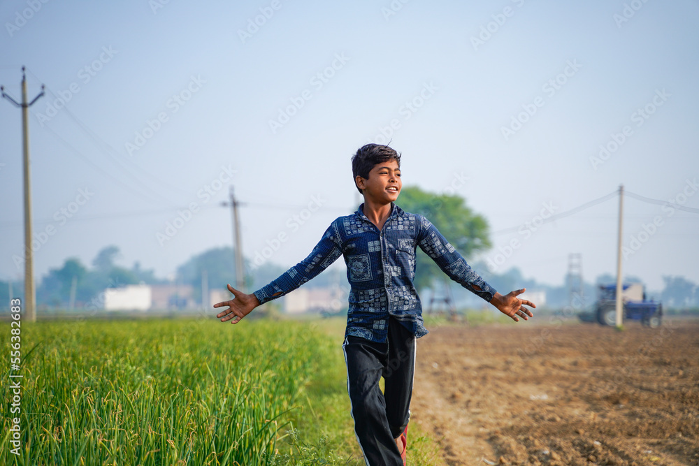 Indian little boy spreading hand and running at agriculture field ...
