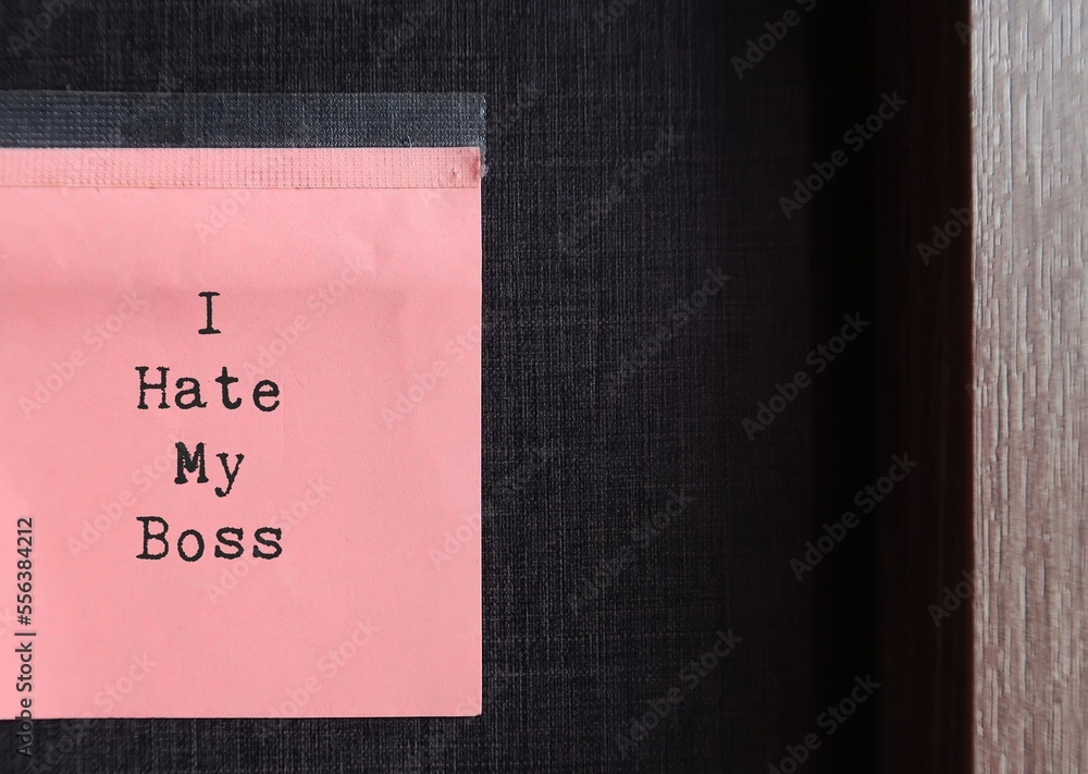 Pink stick note with text typed I HATE MY BOSS on the office wall ...