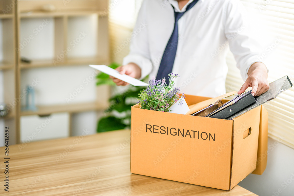 Resignation letter and cardboard box on the table, termination and ...