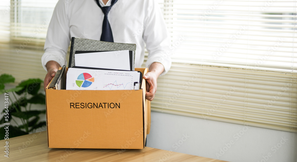 Resignation letter and cardboard box on the table, termination and ...