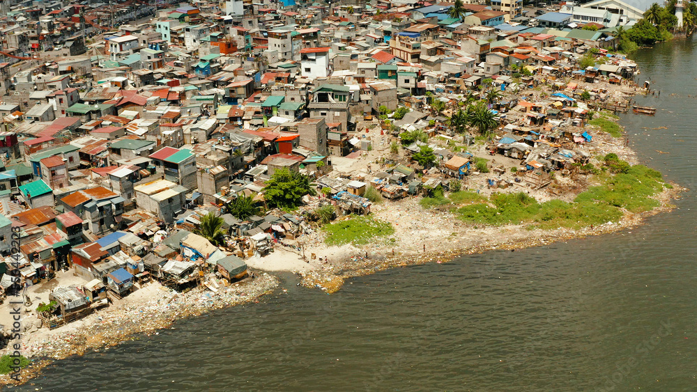 Slums in Manila near the port. River polluted with plastic and garbage ...