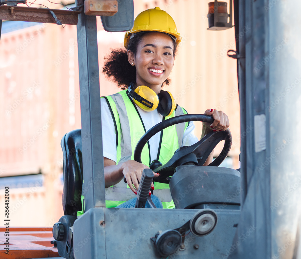 Young female foreman employee driving forklift at shipping container ...