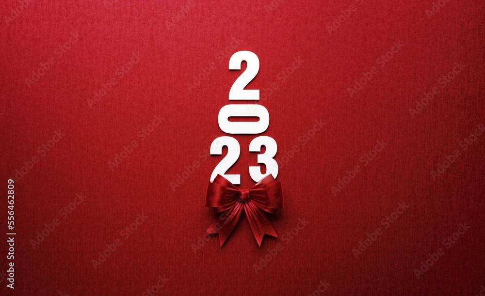2023 text forming a Christmas tree and is tied with red ribbon on red ...