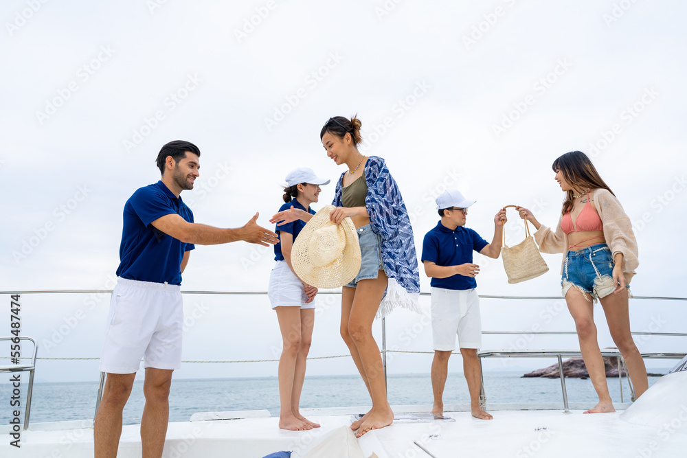 Man and woman yacht crew in uniform helping group of passenger tourist ...