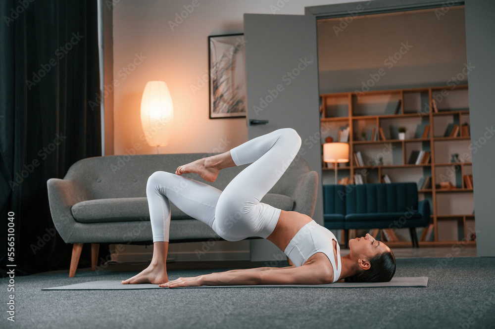 Exercise for legs and spine. Young woman with slim body type in white ...
