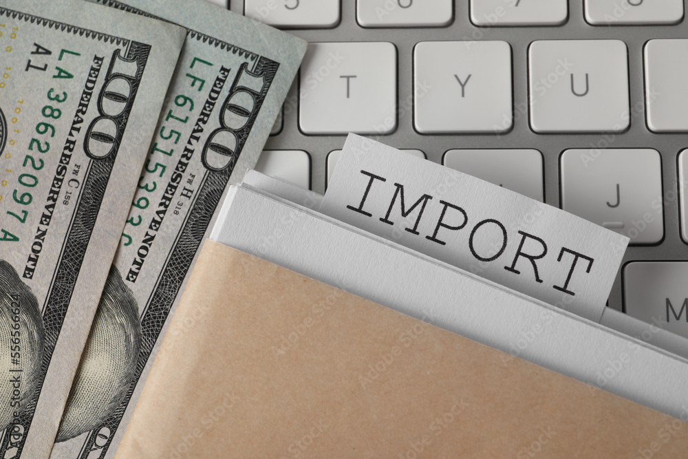Note with word Import in documentation and dollar banknotes on computer ...