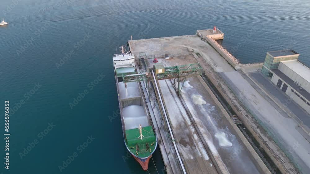 loading salt into a cargo ship for transportation by sea. The ship is ...