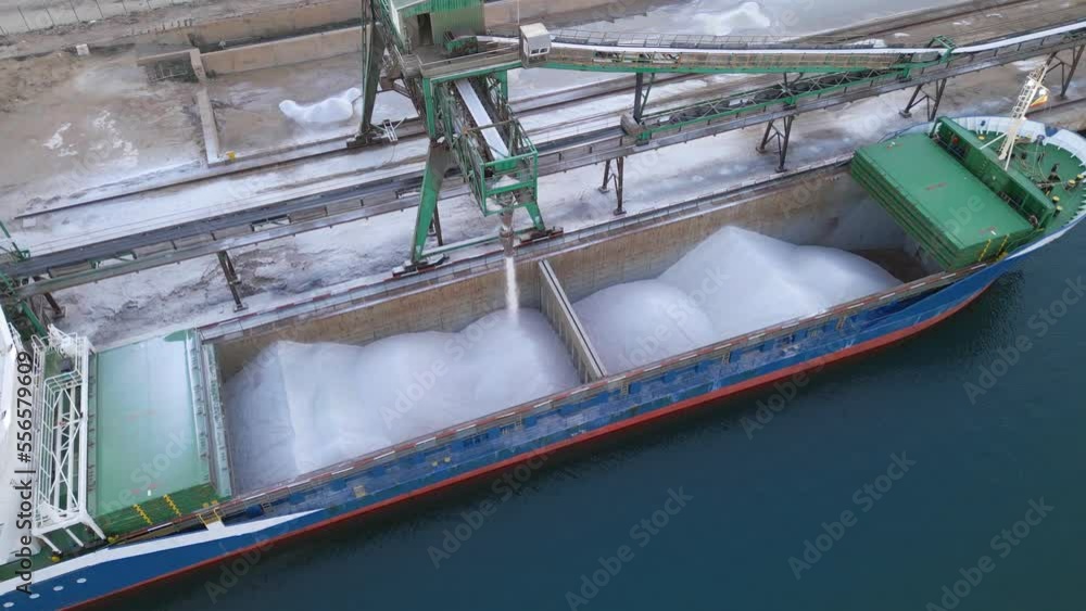 loading salt into a cargo ship for transportation by sea. The ship is ...