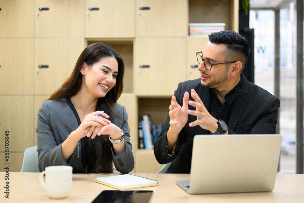 Happy business team talking and brainstorming together in workplace ...