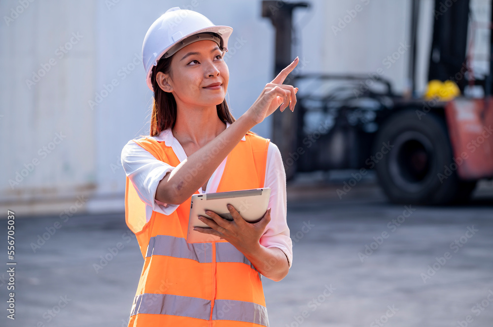 Smile Asian woman logistics worker wear safety helmet and protect suite ...