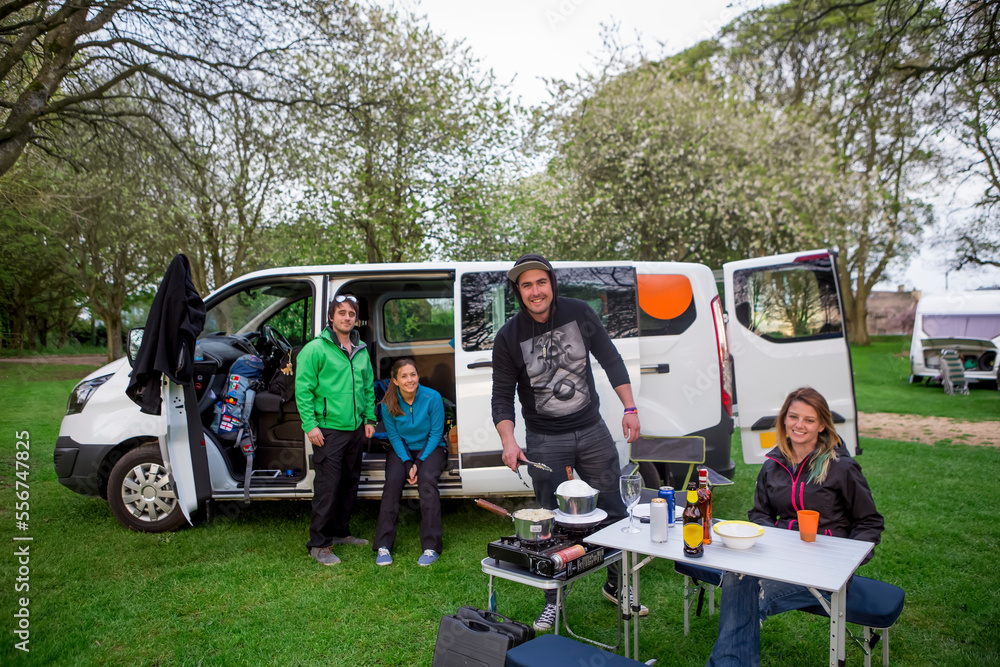 Setting up camp outside of a modified caravan camper; Bourton-on-the ...
