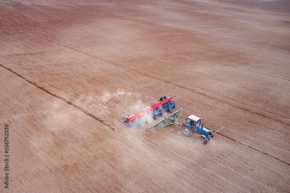 Spring. Introduction of seeds into the soil. The work of a tractor with ...