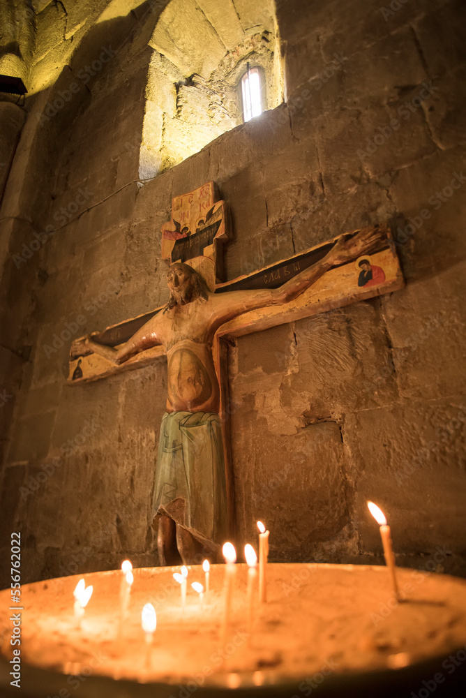 Candles burn in front of a wooden depiction of Jesus Christ on the ...