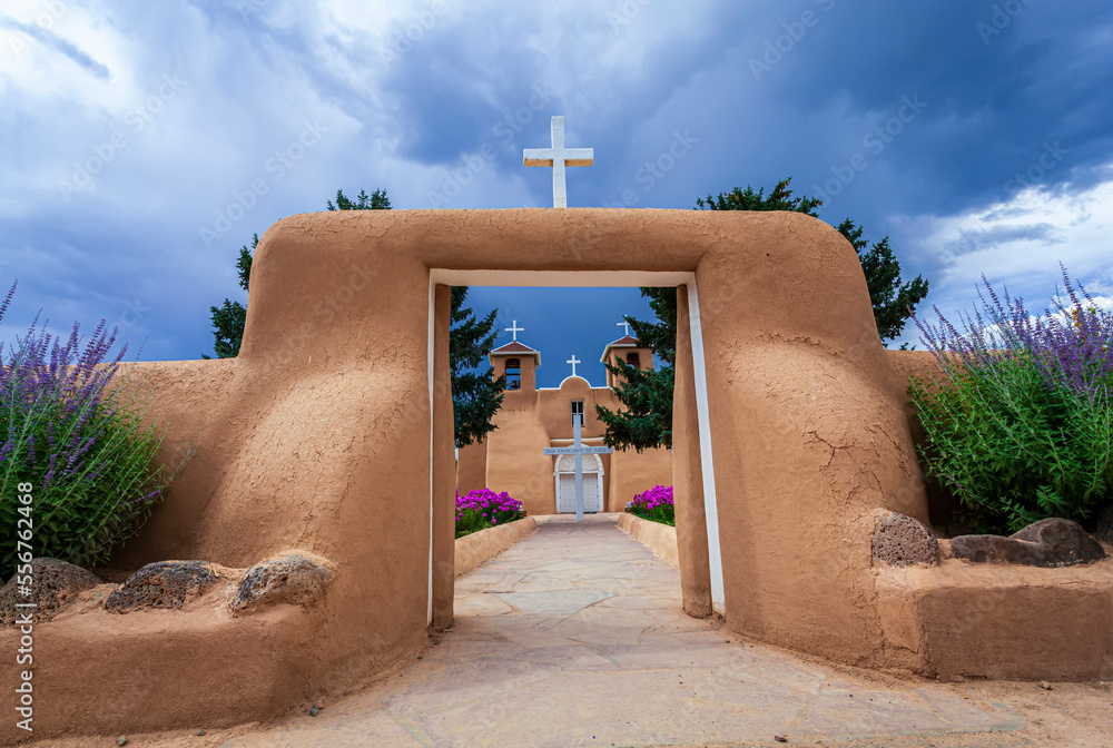 Looking through the adobe gates to the courtyard entrance and facade of ...