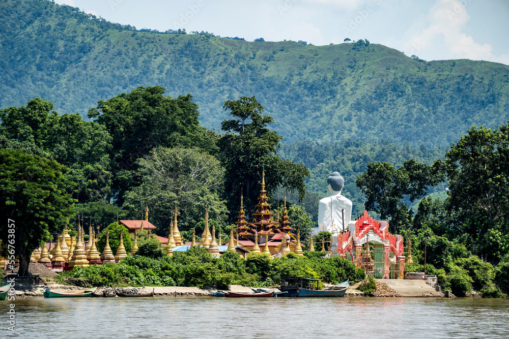 View from Behind of a Giant Buddha beside pagodas and golden stupas on ...