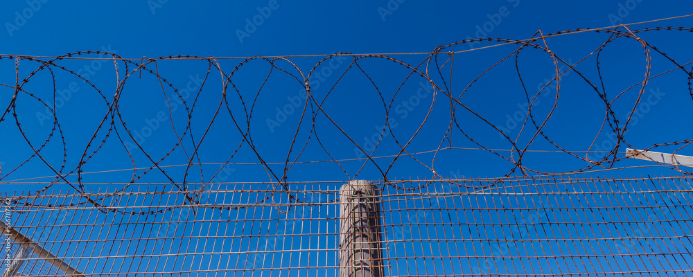 Barbed wire fence against a blue sky at Robben Island Prison; Robben ...