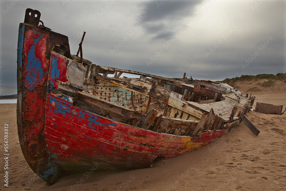 Colourful weathered shipwreck lying in sand dunes at Crow Point, at the ...