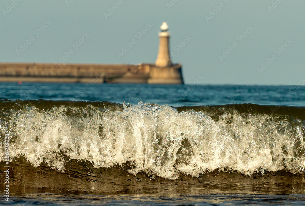Surf washing up on beach in the foreground with Tynemouth North Pier ...