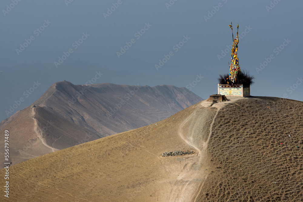 Tower of Buddhist prayer flags on a sandy mountaintop at Labrang ...