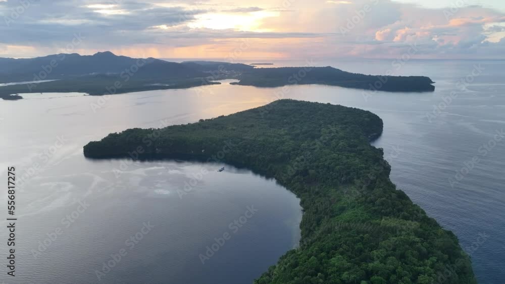 A tranquil sunrise illuminates a remote tropical island in the Solomon ...