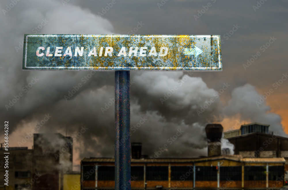 The clean air ahead slogan on the road sign in front of the factory ...