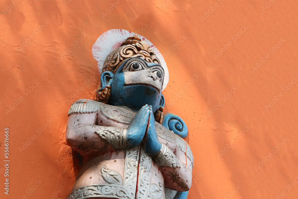 Blue monkey with arms folded in Namaste greeting against the background ...