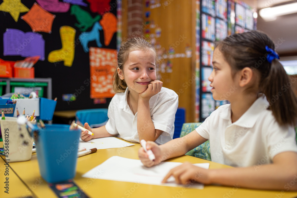 Two Young Schoolgirls at a Desk in a Classroom Stock Photo | Adobe Stock