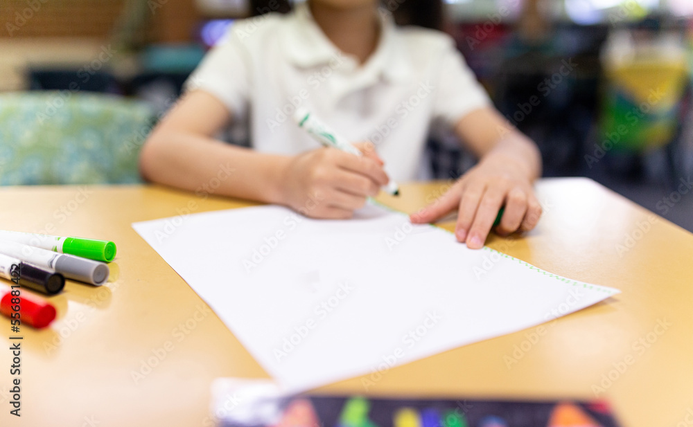 Young student drawing with markers in classroom Stock Photo | Adobe Stock