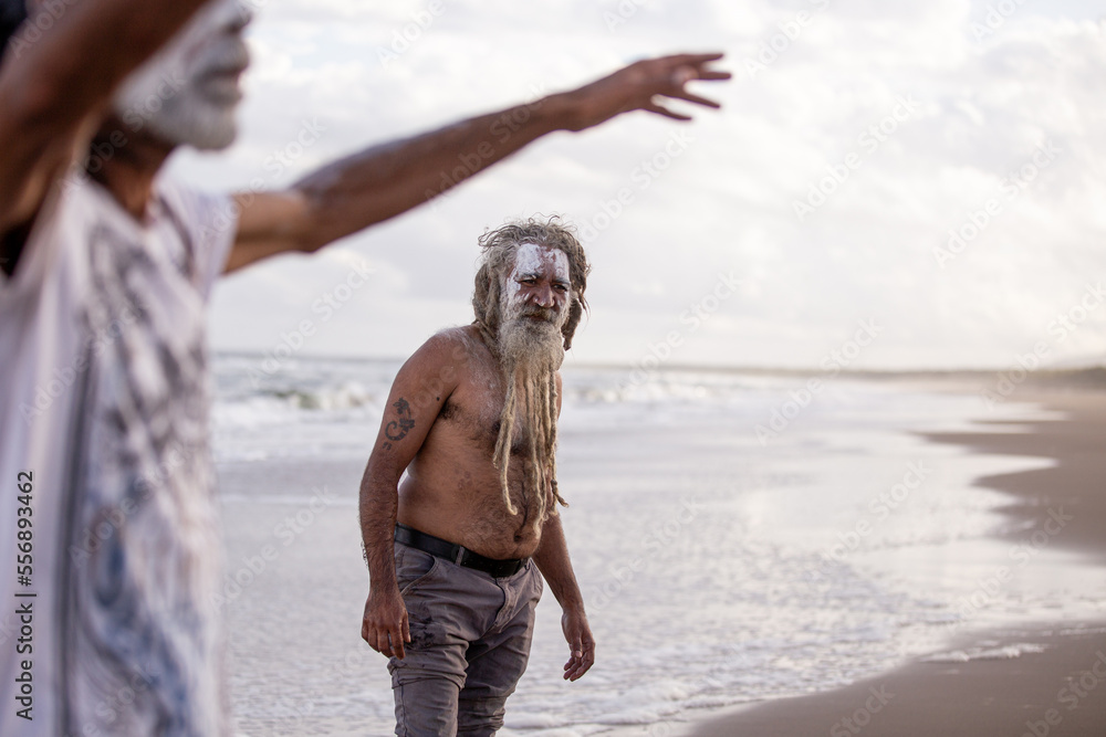 Aboriginal middle aged man listening to another Aboriginal man talking ...