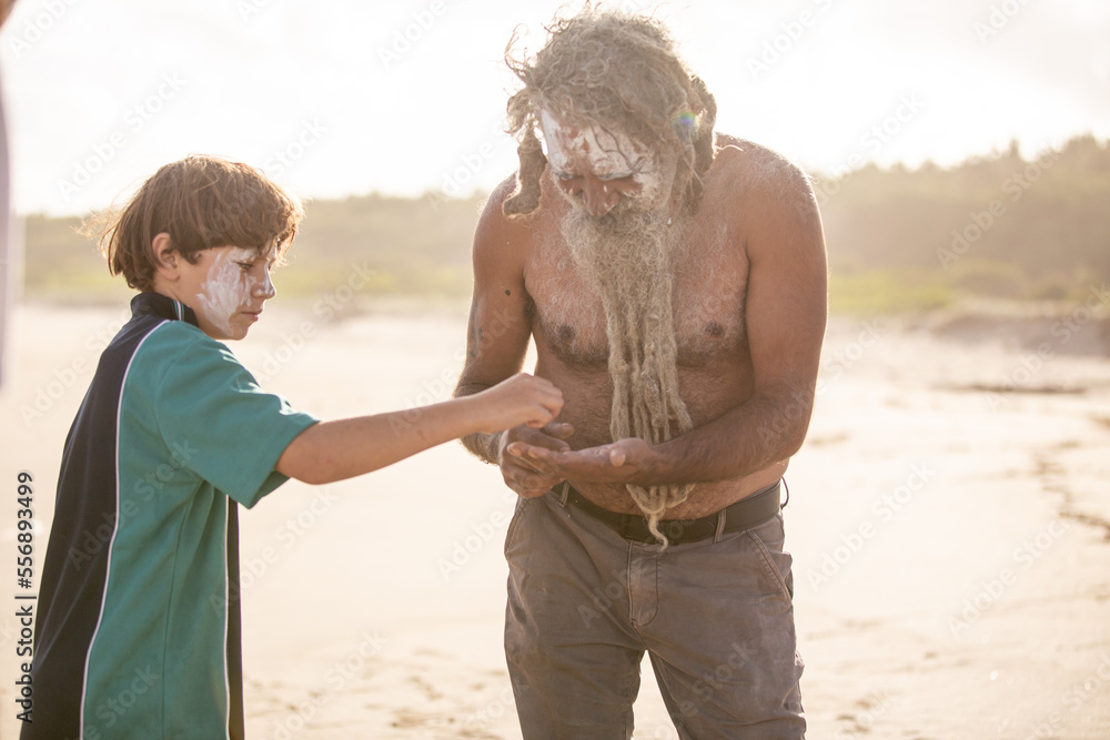Aboriginal father helping son on a beach Stock Photo | Adobe Stock