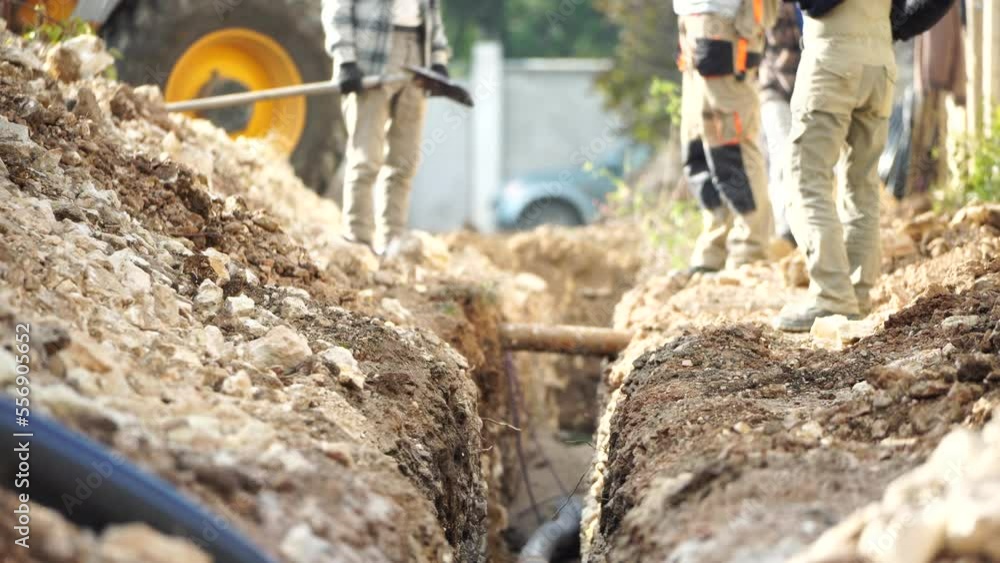 Excavator digs a trench to lay pipes. Close up of an excavator digging ...