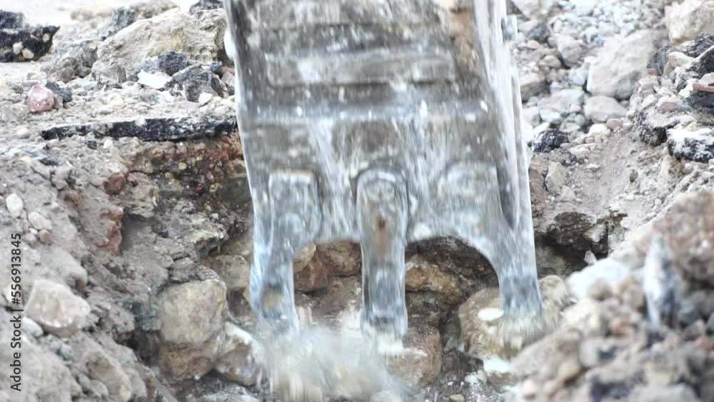 Excavator digs a trench to lay pipes. Close up of an excavator digging ...