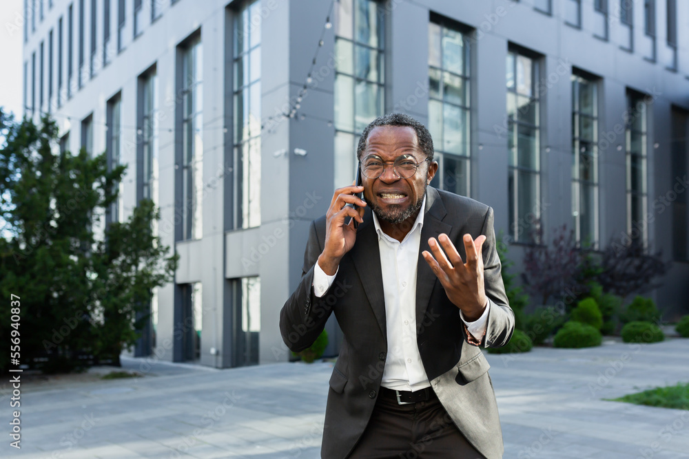 Angry african american boss arguing and shouting while talking on the ...