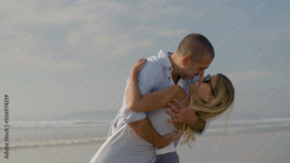 Loving Caucasian couple kissing at seashore, walking at sunset along ...