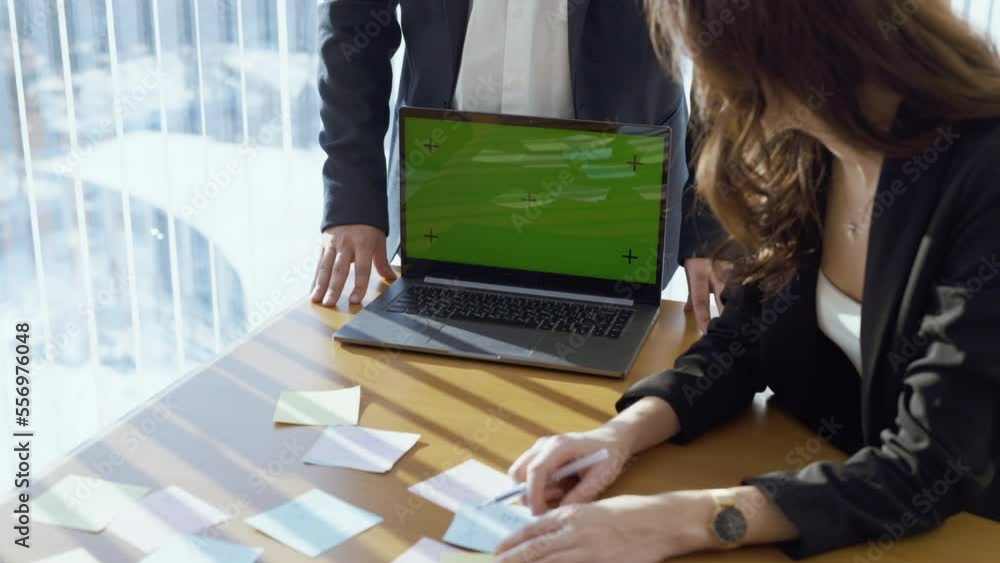 Office scene of coworkers discussing upcoming projects behind the desk ...