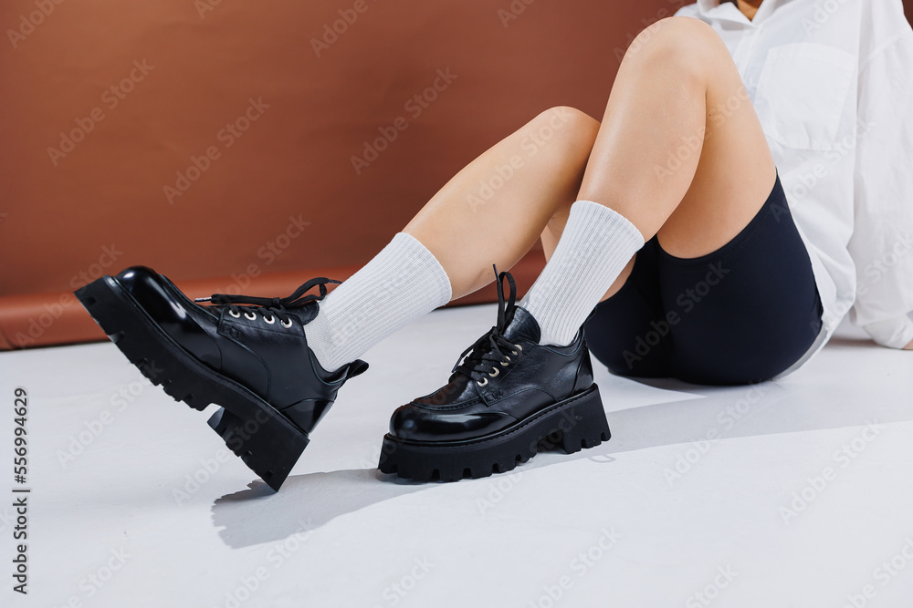 Beautiful female legs in black leather lace-up loafers. Female legs ...