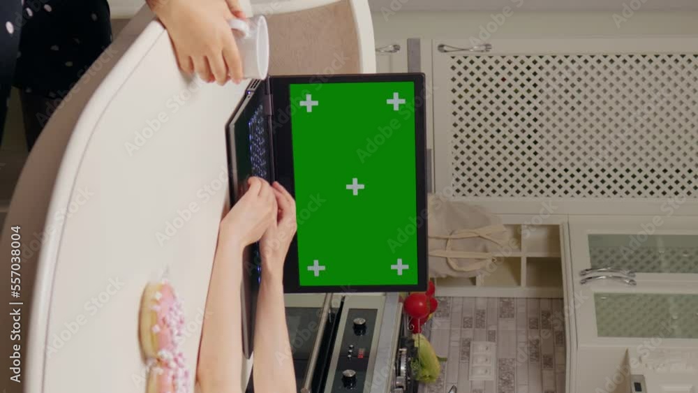 Vertical Screen: Two female sit at a table in the kitchen in front of ...