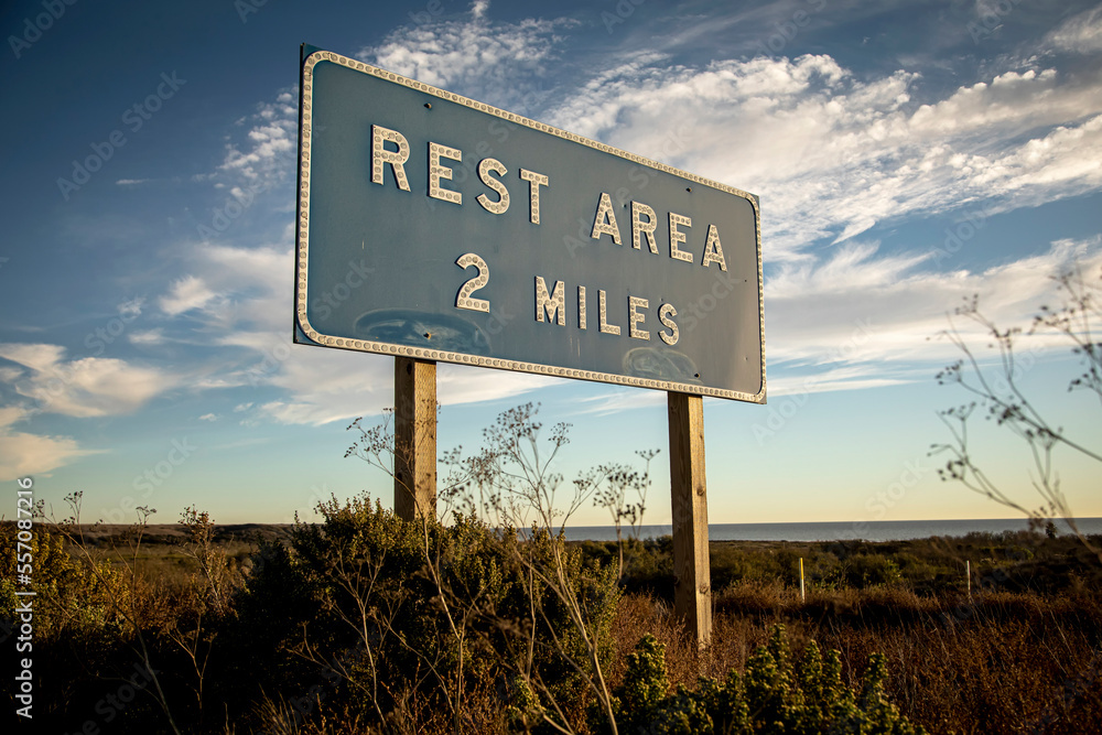 Blue road sign stating Rest Area two miles ahead against a blue sky ...