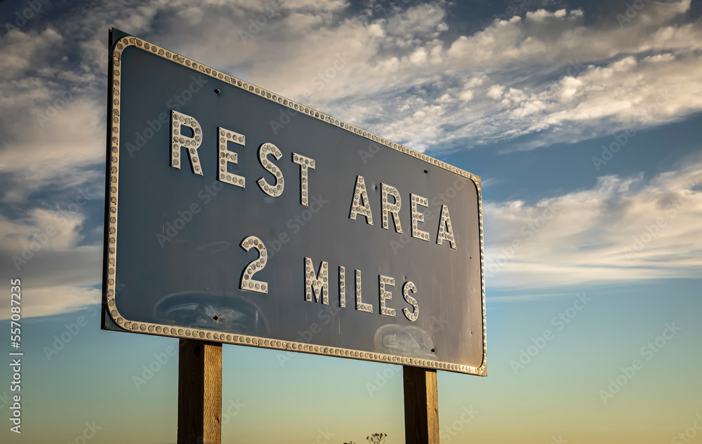 Blue road sign stating Rest Area two miles ahead against a blue sky ...