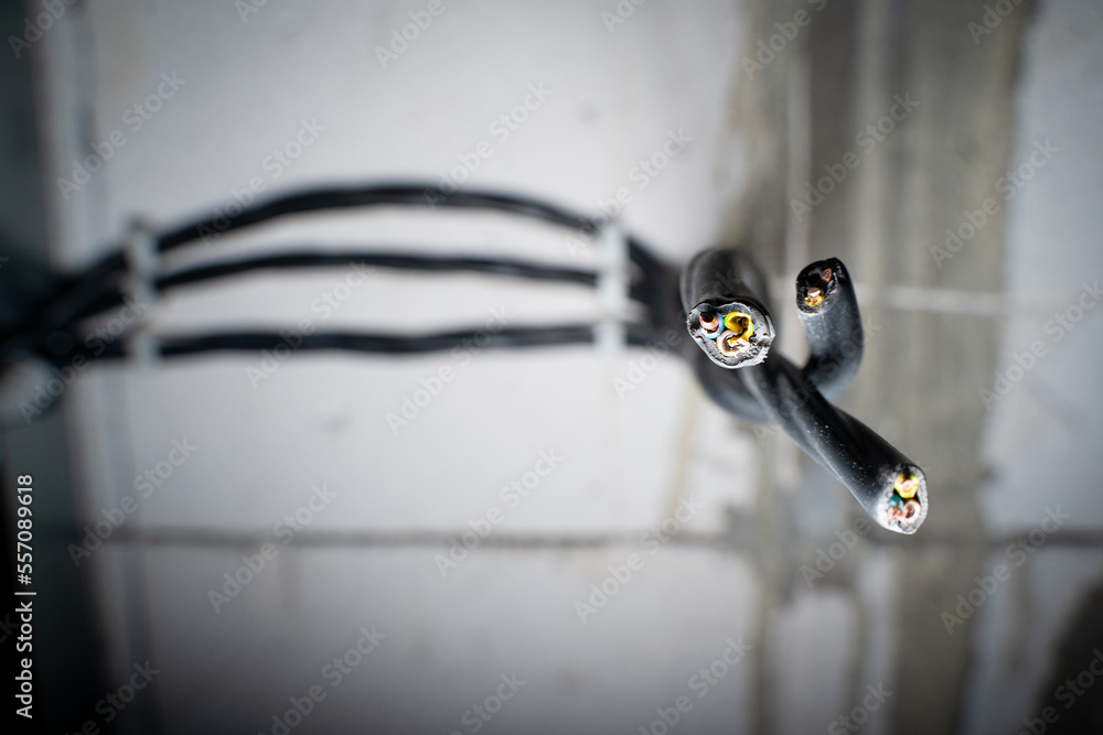 Power three-core copper cable close-up. Electrical wiring on the walls ...