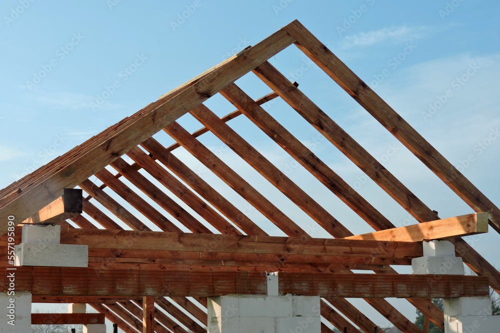 A timber roof truss in a house under construction, walls made of ...