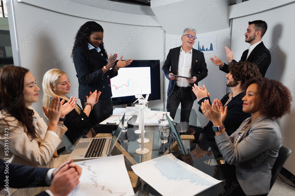 Teamwork with diverse ethnicity is sitting at office clapping hands ...