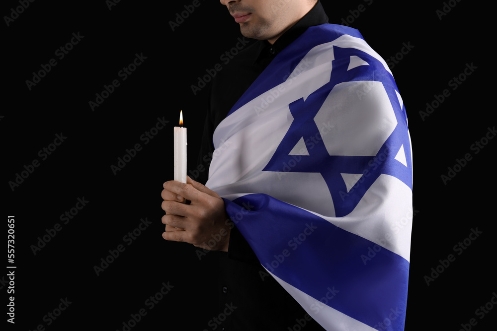 Jewish man with candle and flag of Israel honoring victims of Holocaust ...