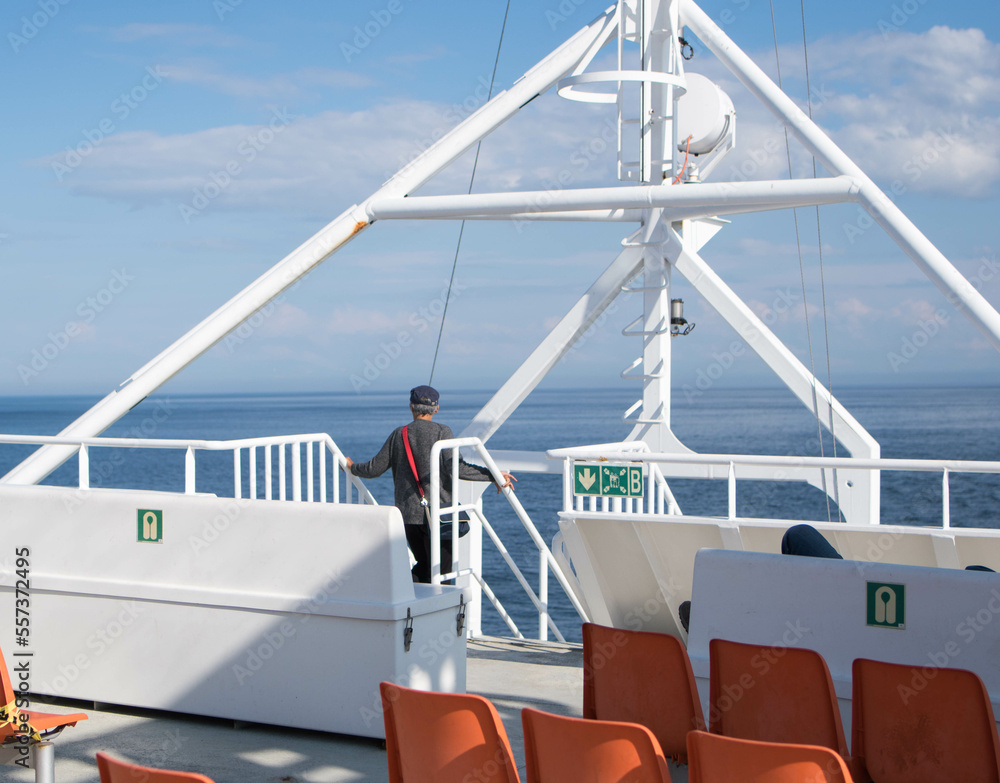 Rear view of a man on a boat in the sea. Man watching the sea. Man on a ...