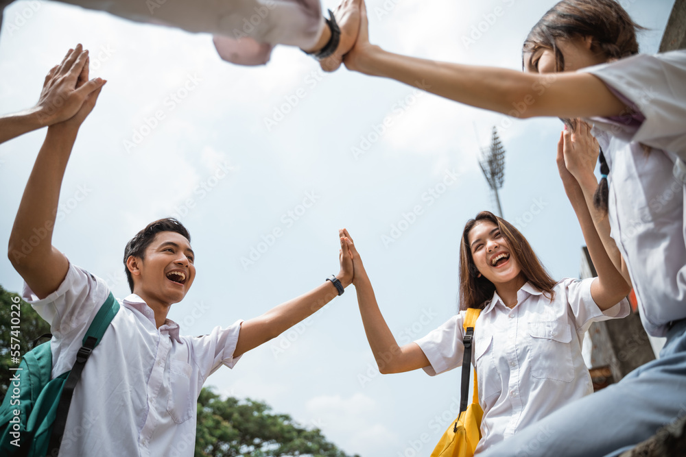 Group of high school students forming circle symbol of unity while ...