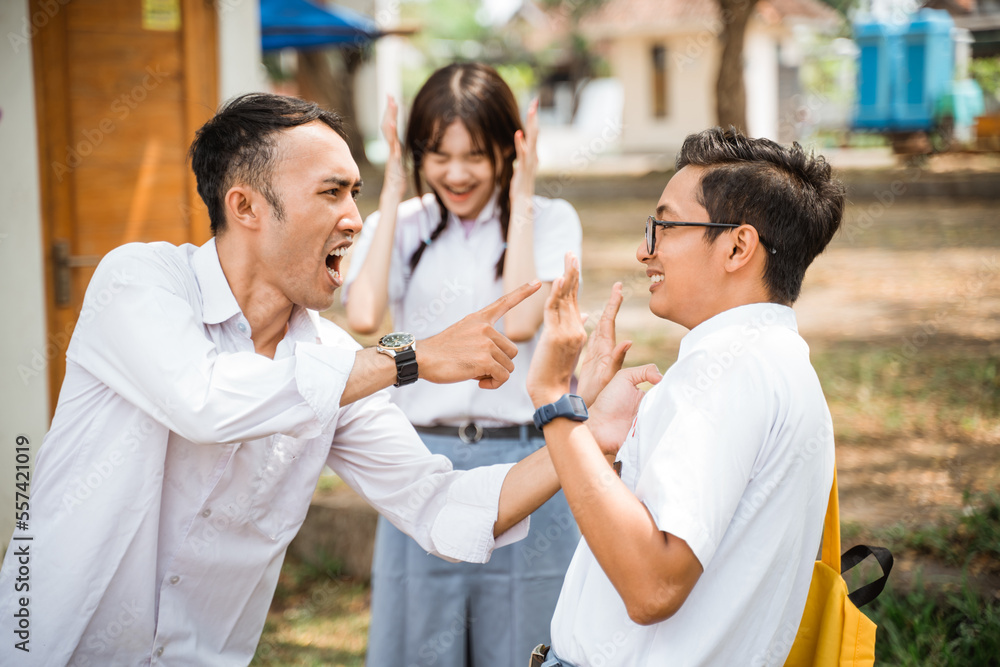Two male high school students fighting with scared girl screaming ...