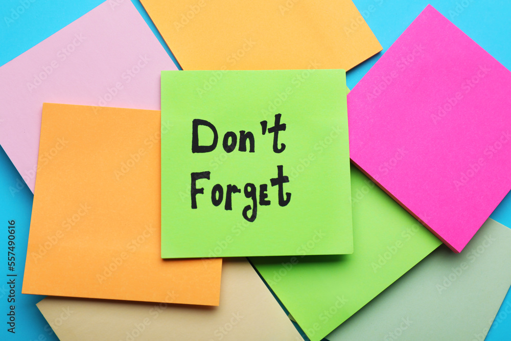 Paper with phrase Don' t Forget and many empty notes on blue background ...