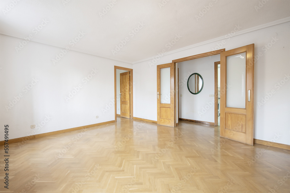 Empty living room with double oak doors with glass cabinets and access ...